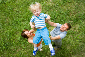 Portrait of woman and man throwing up joyful boy Royalty-Free Stock ...
