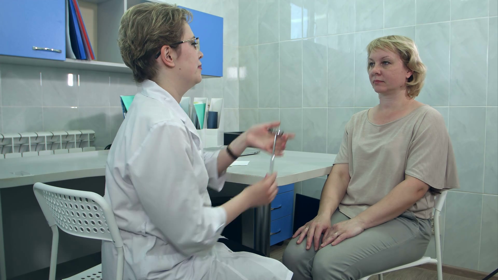 Female neurologist performing neurological tests on a female patient in ...