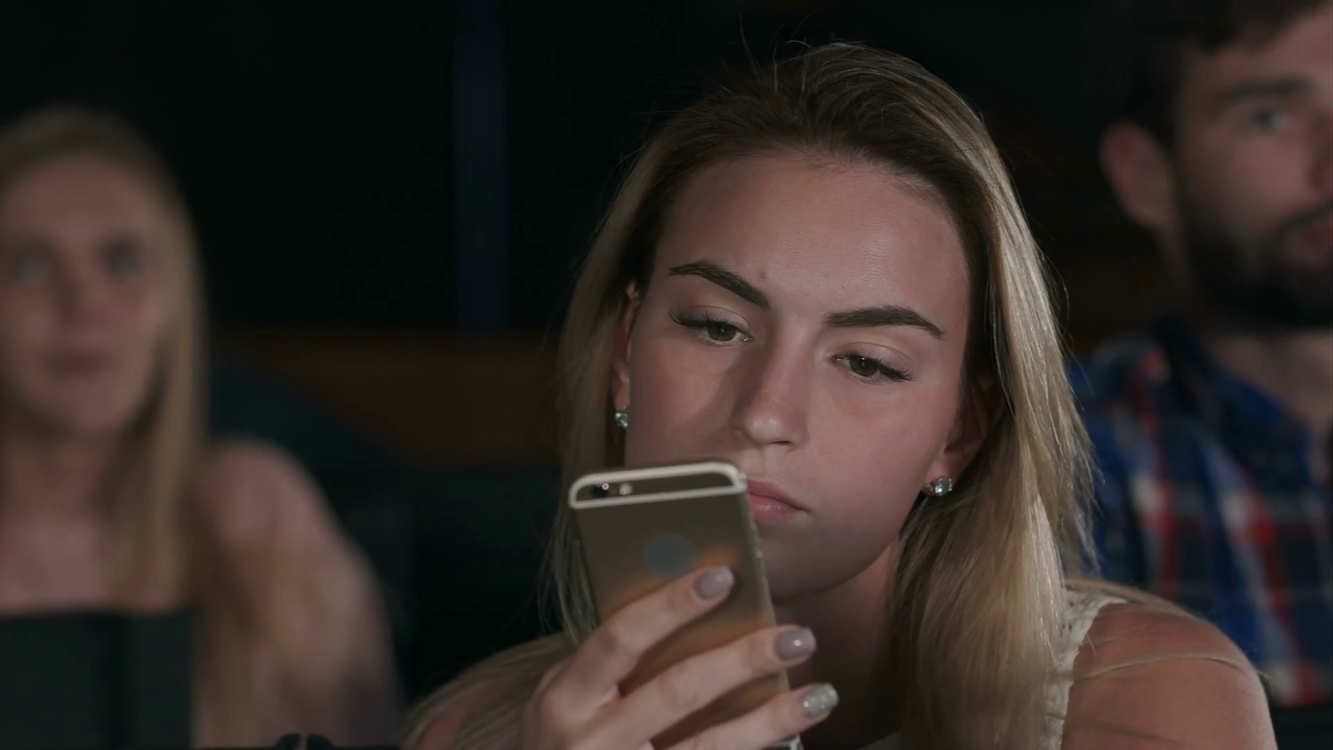 Shot of a beautiful young female texting during movies at the local ...