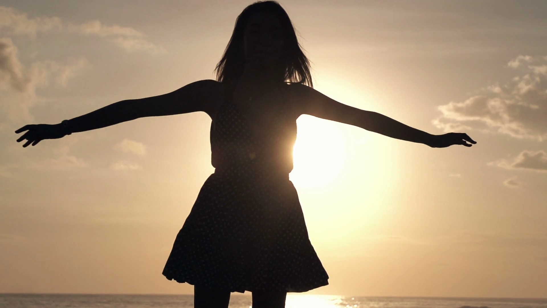 portrait of happy woman turning around in the beach during sunset, slow ...