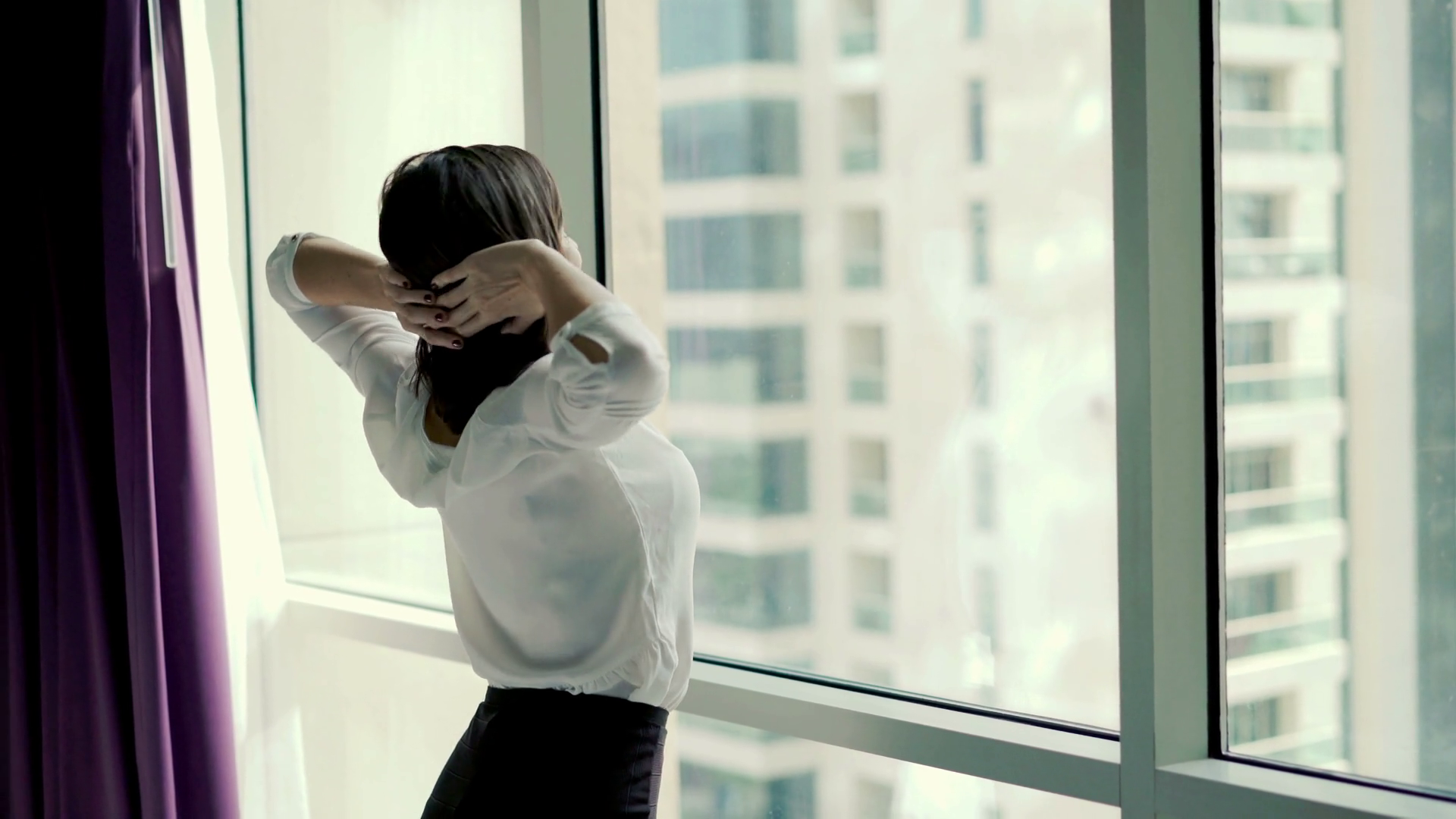 Young businesswoman stretching her arms by window in the office, 4K ...
