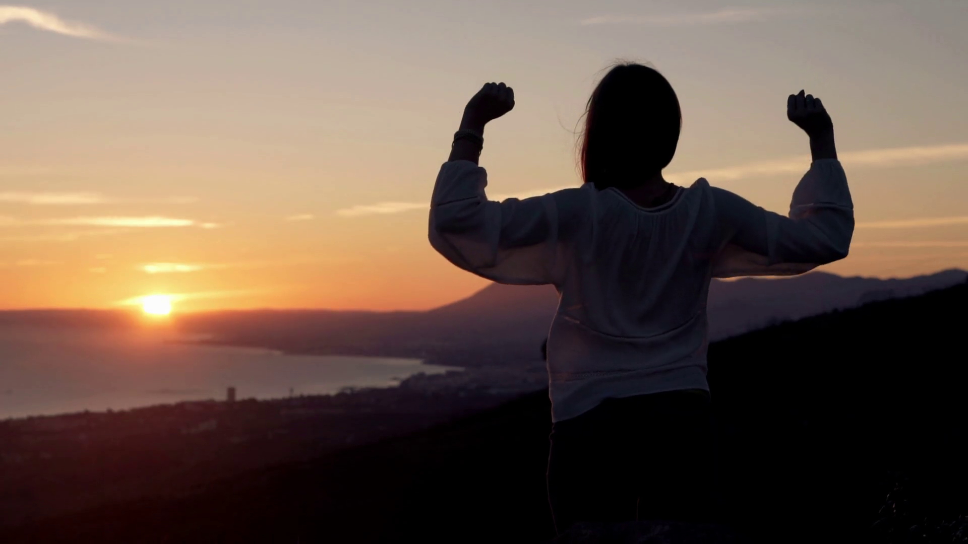 Young woman raising arms to the sky during sunset Stock Video Footage ...