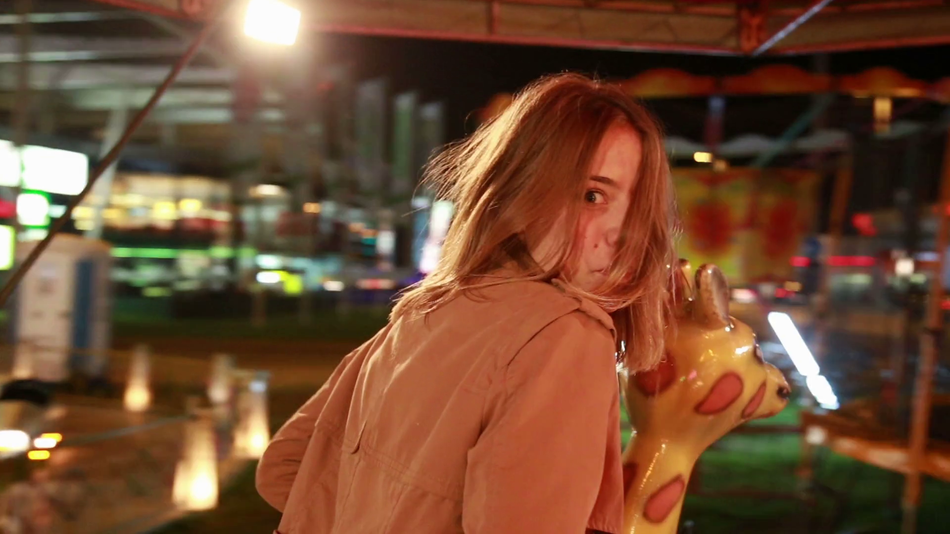 Close up of beautiful woman riding carousel in amusement park, waving ...