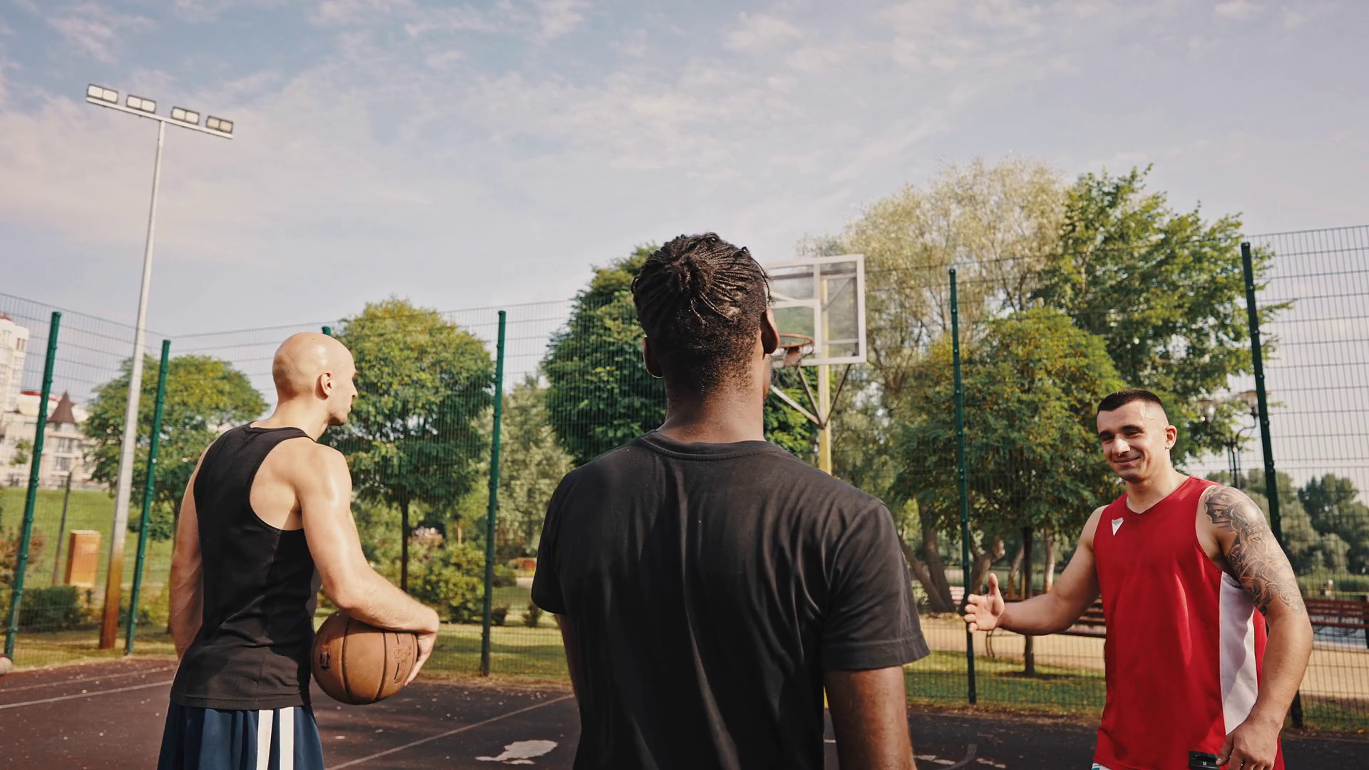 Four young sportsmen basketball players hug and shake hands after the ...