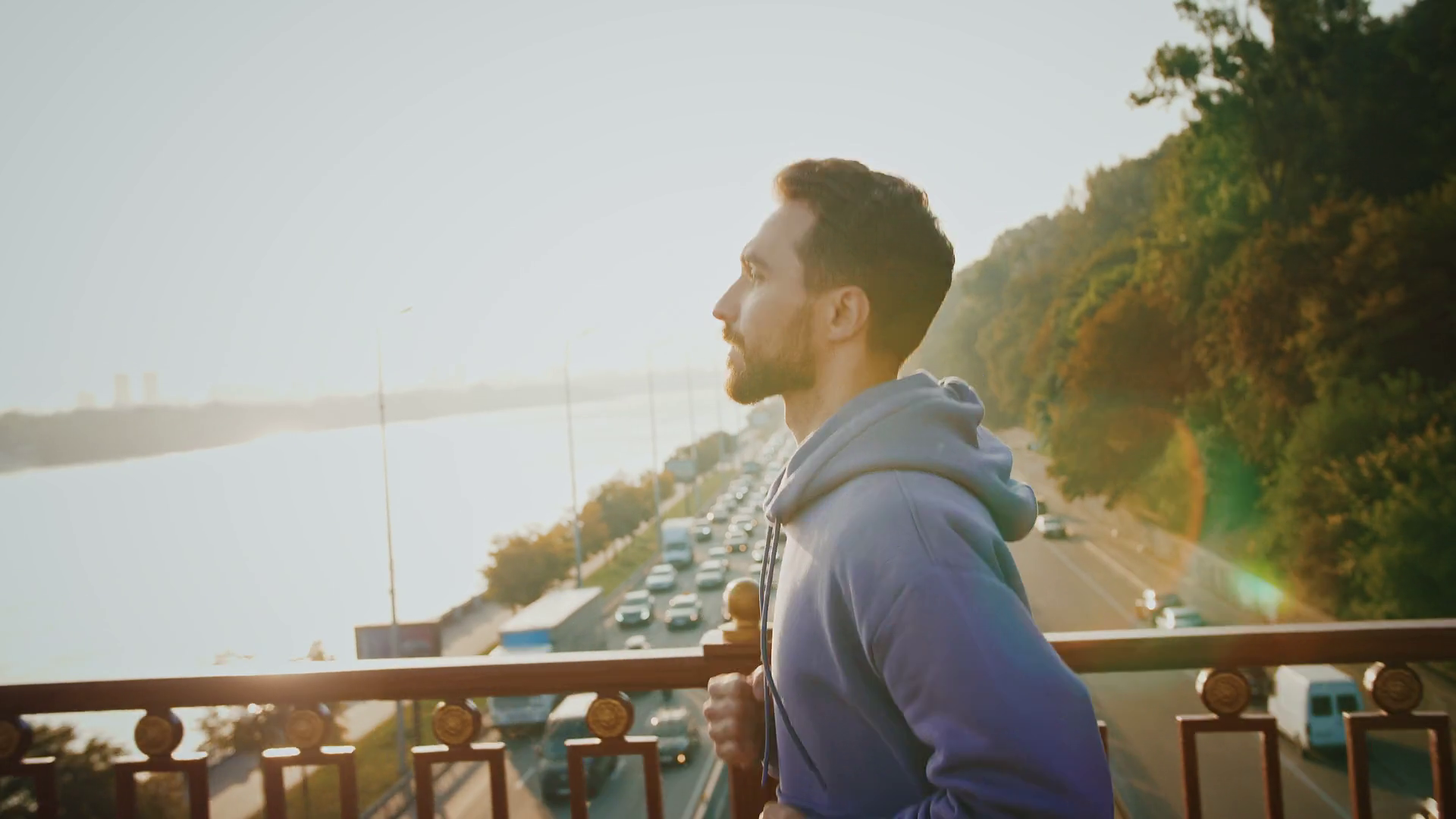 Active lifestyle. Profile of sporty man running on city bridge early in ...