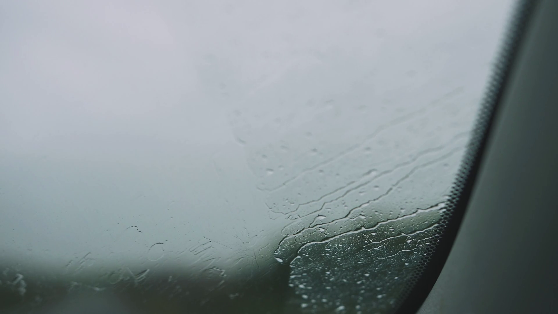 Cinematic shot of windshield wiper with rain drops on the dramatic sky ...