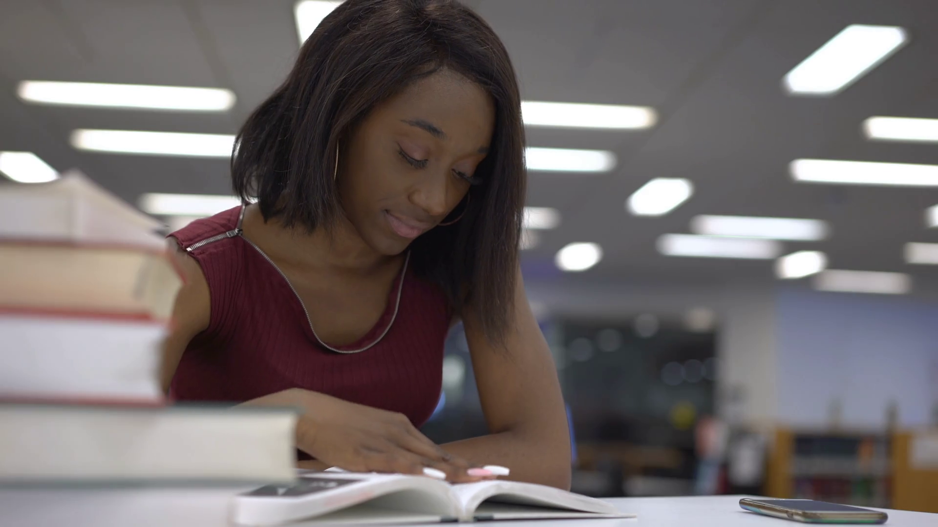 Young girl yawning while reading book in library 4k Stock Video Footage ...