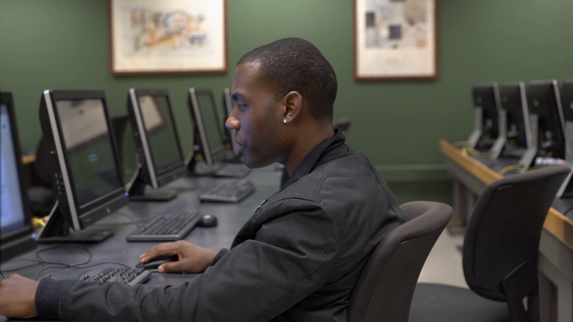 Young male sitting in computer lab smiling at screen 4k Stock Video ...