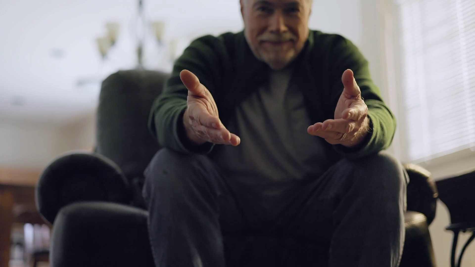 A smiling senior man happily beckoning for a small child or animal to ...