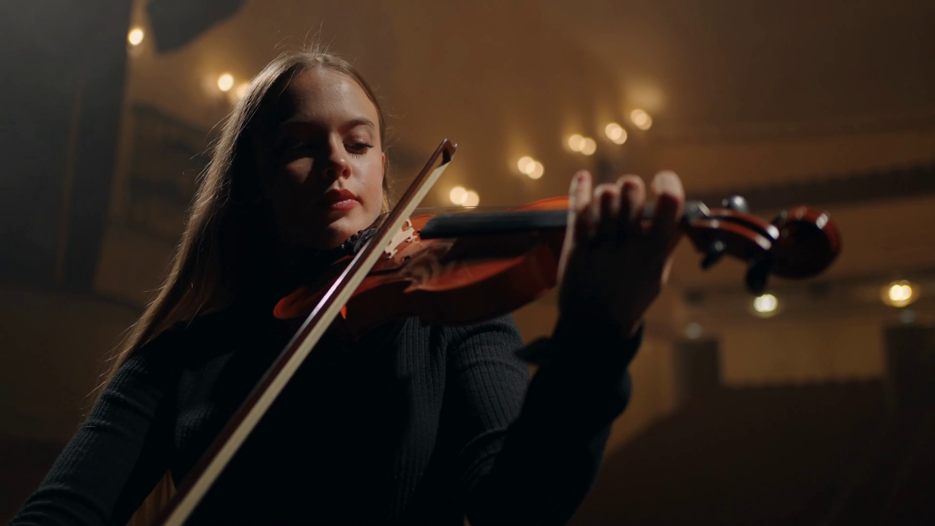 lady is playing fiddle in on scene in opera house, classic music ...