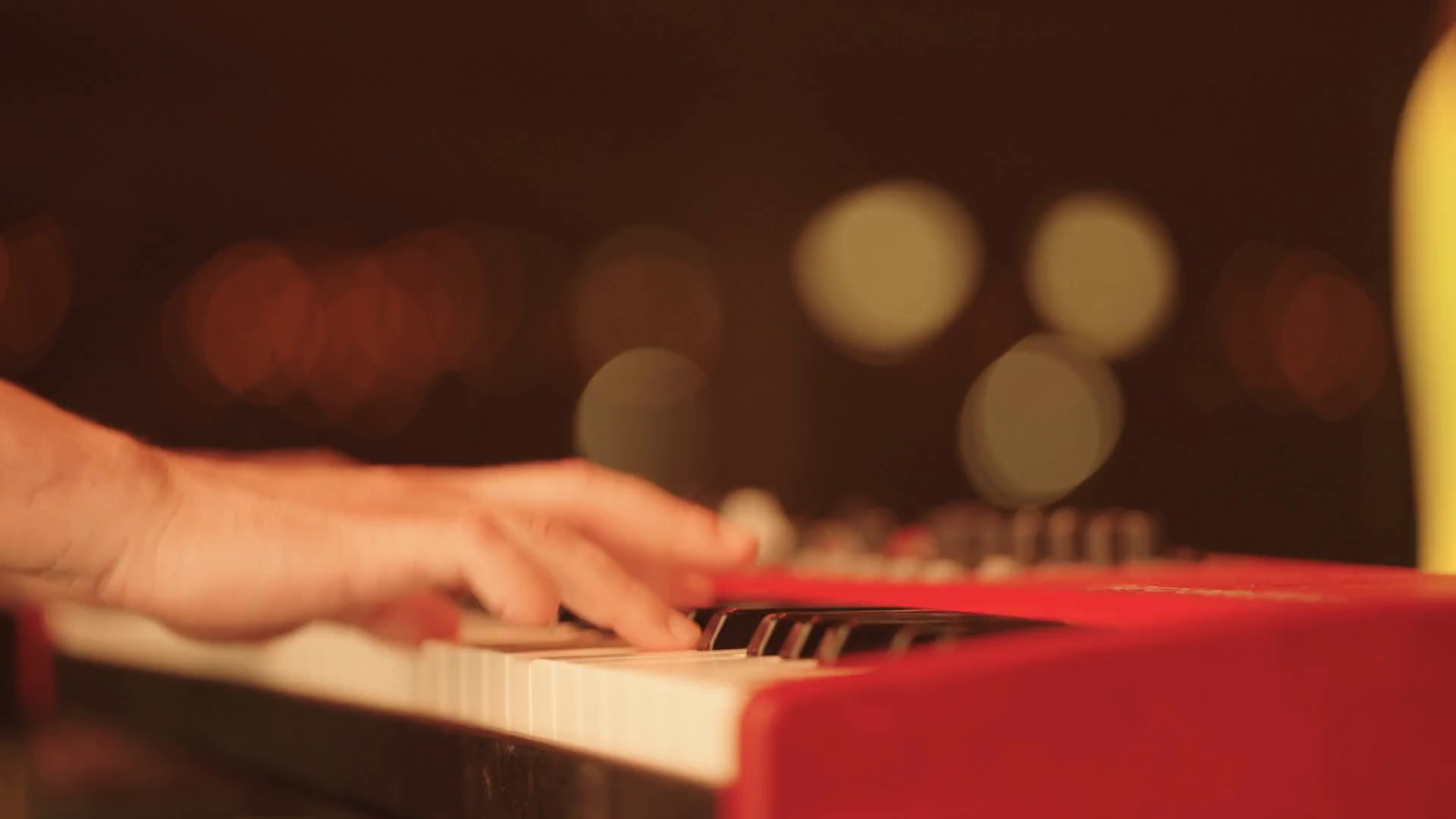 musician plays on keyboard, closeup view during rock gig on stage ...