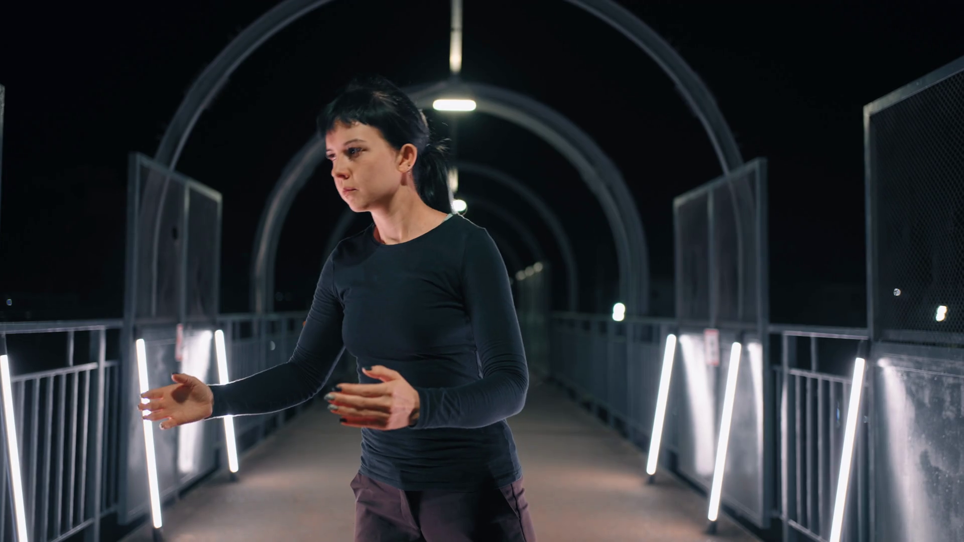 dance performance on pedestrian bridge in city in night, talented woman ...