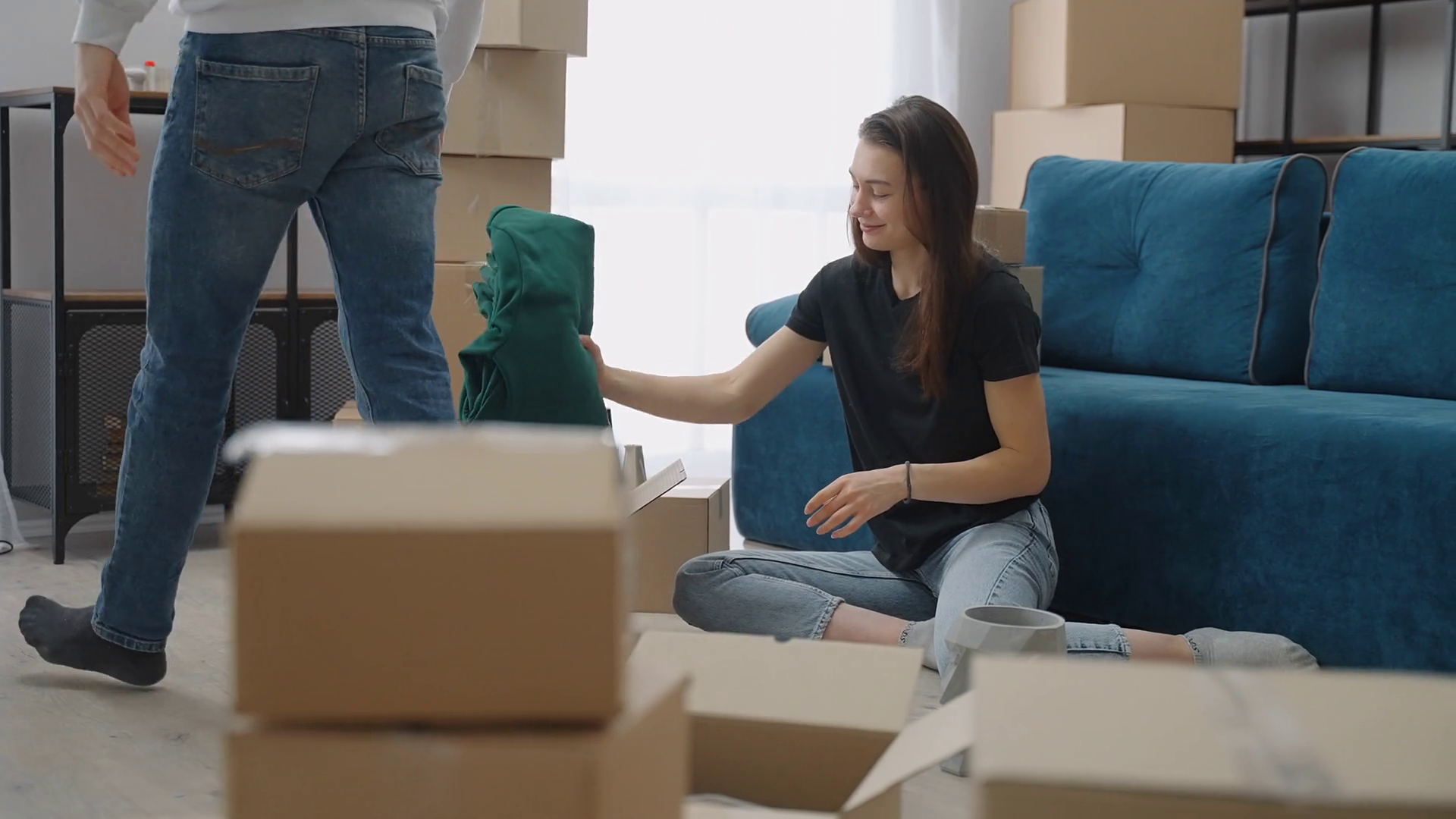 Beautiful girl puts her clothes in cardboard boxes for the move. The ...