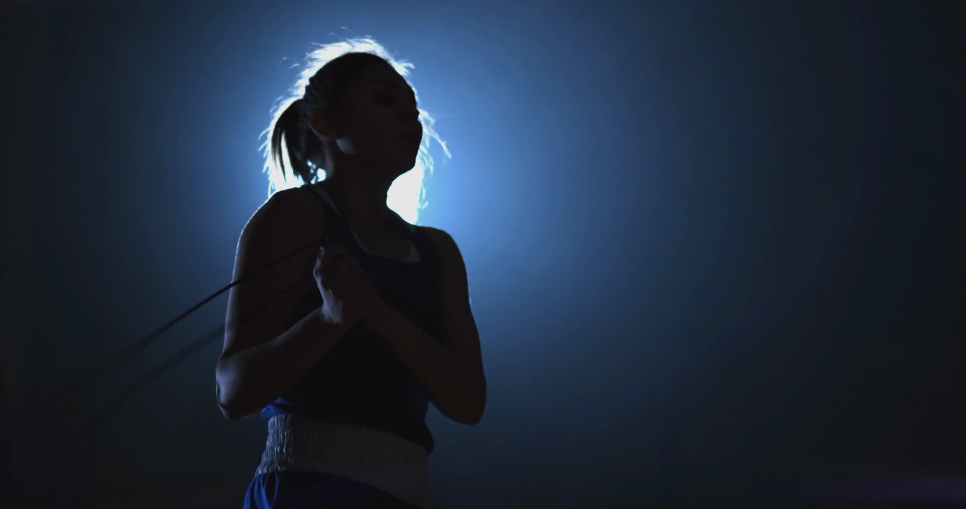 Woman boxer jumping on skipping rope in the Boxing hall with a ring ...