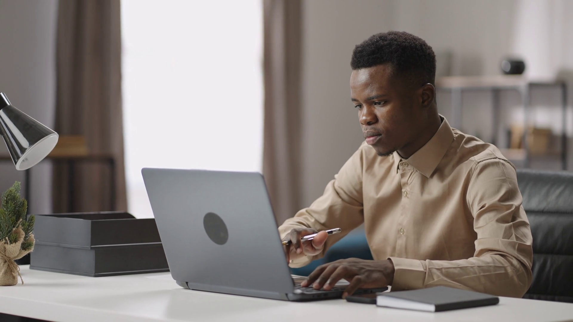 young black man is studying online, viewing learning video on laptop ...