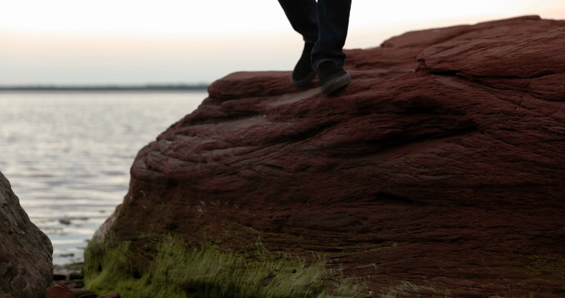 Man Jumping Down Off Red Rocks Next To Ocean Stock Footage SBV ...