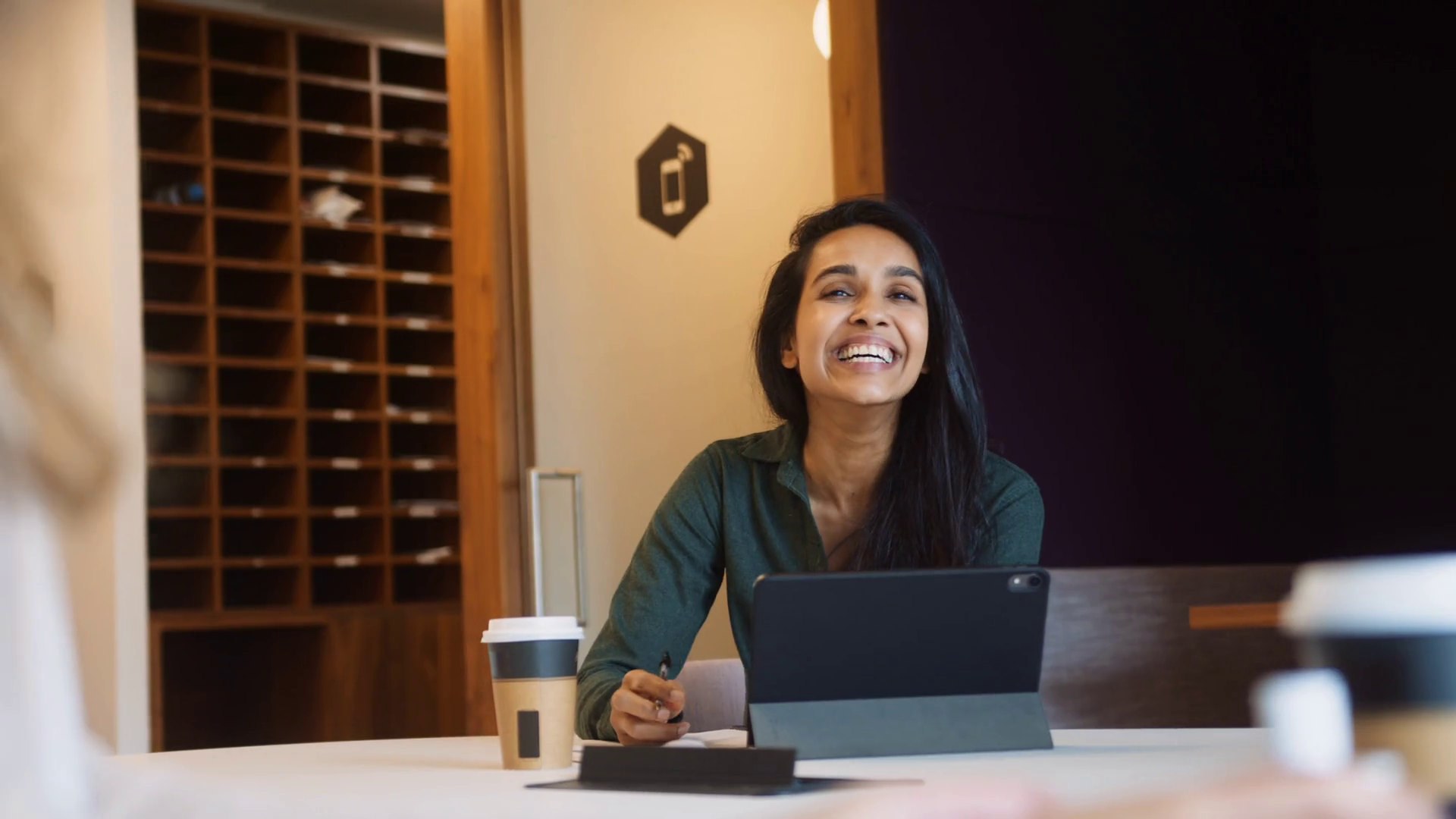 Two businesswomen have socially distanced meeting around table in ...