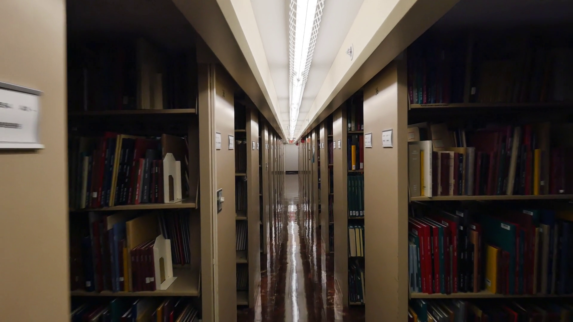 Point of view walking through the stacks of a large university library ...