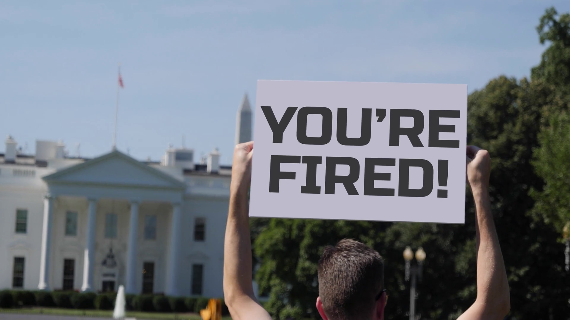 A man holds a GAME OVER protest sign outside the White House. People ...