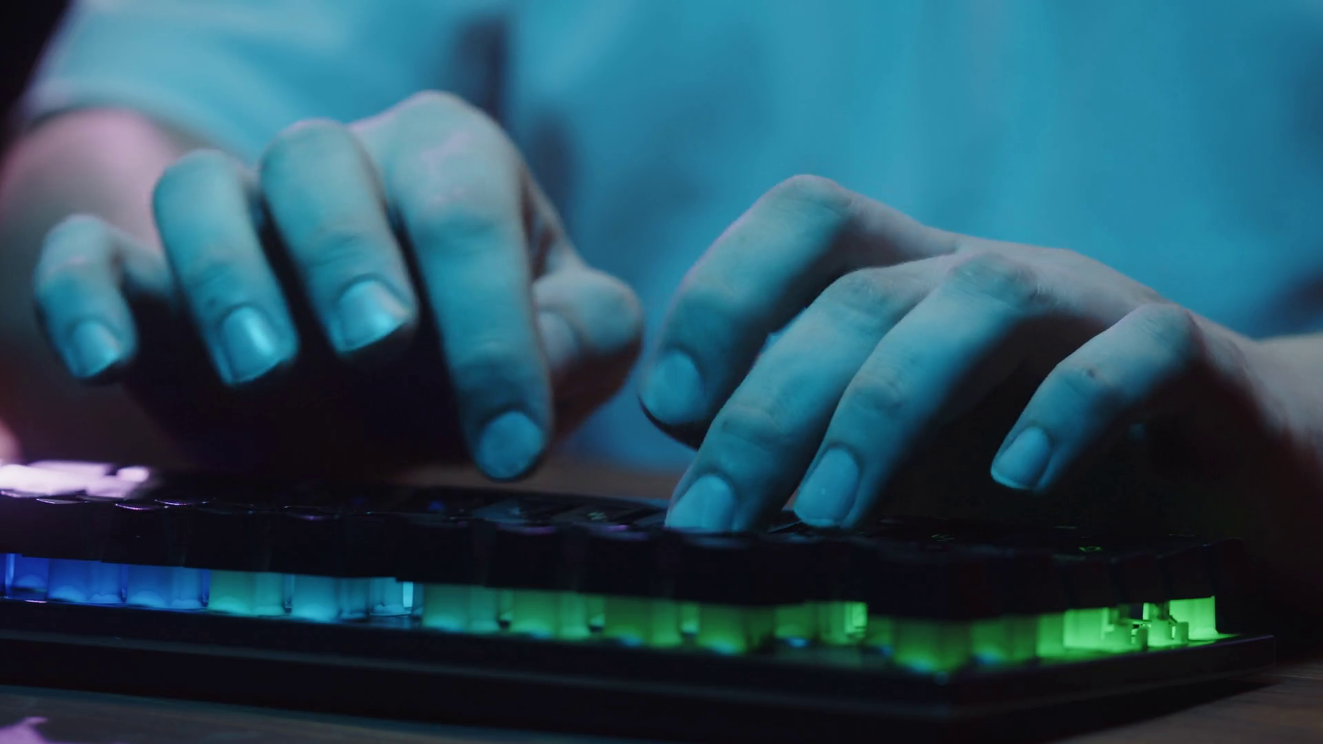 Gamer typing on backlight keyboard close-up, man playing video game ...