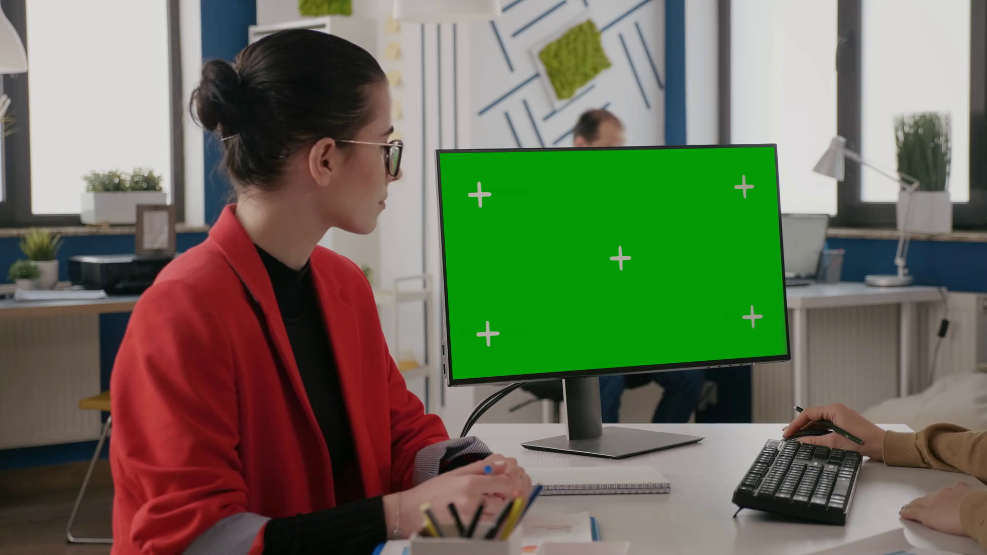 Close up of woman looking at computer with green screen and talking to ...