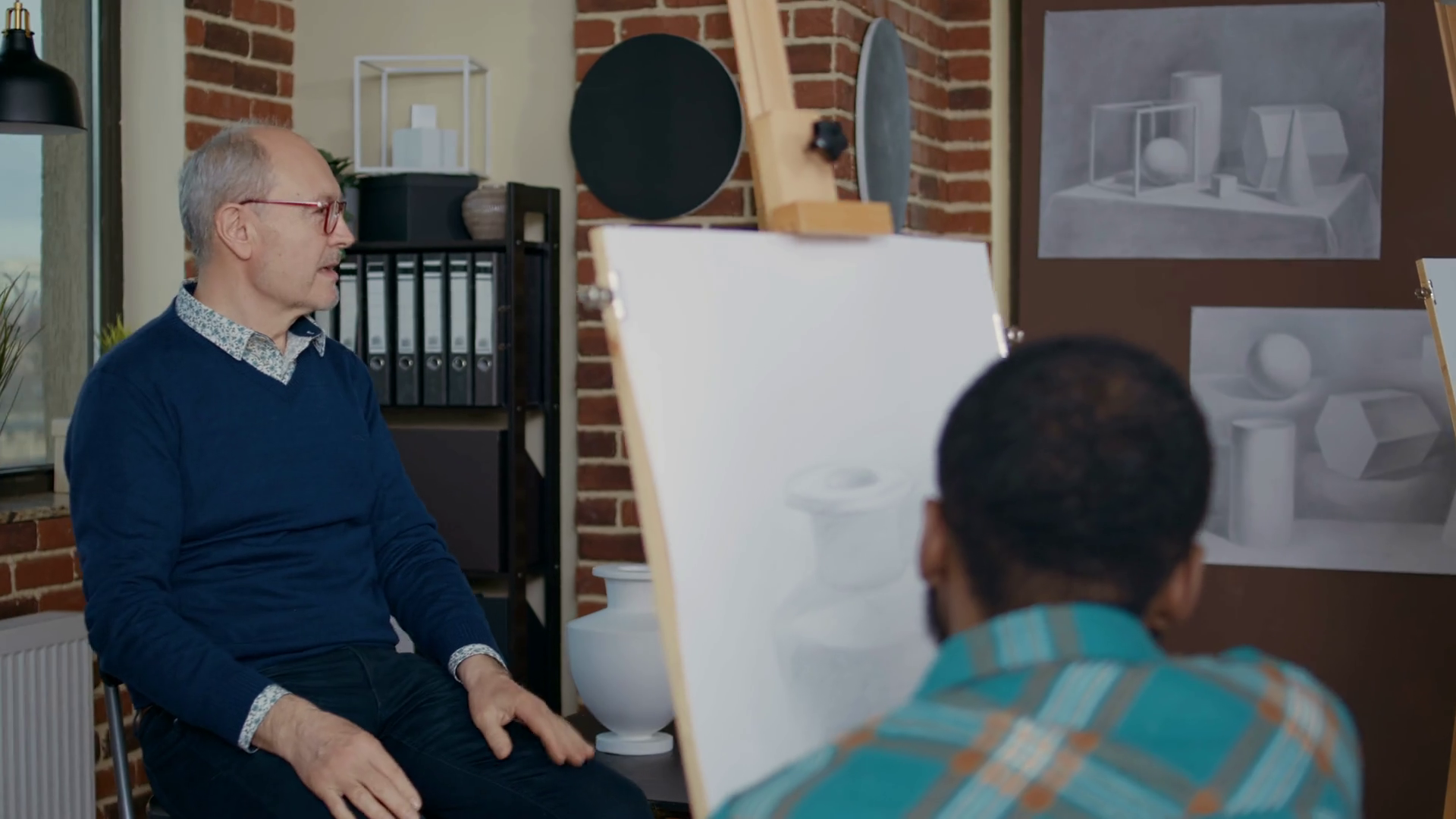 Senior man teaching people in art class to draw on canvas, learning new ...