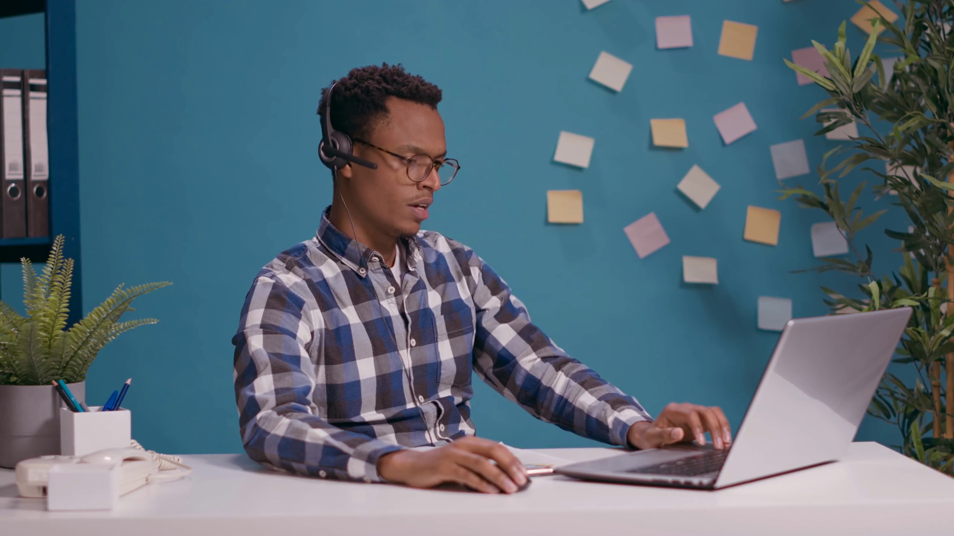 Young man talking with client on phone call at helpline call center ...