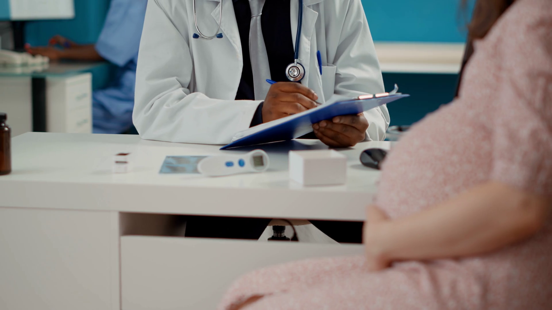 african-american-medic-taking-notes-at-consultation-with-pregnant