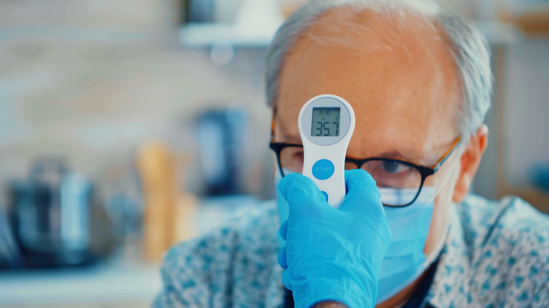 Medical assistance checking senior man body temperature using infrared ...