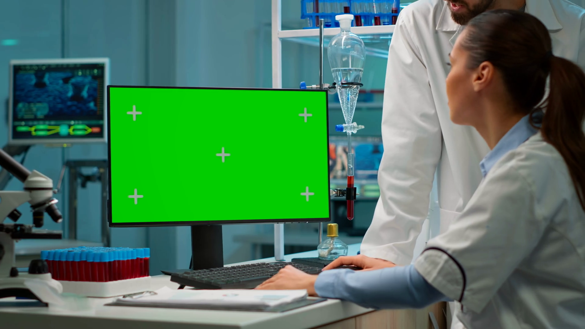 Medical research scientists using desktop computer with green screen ...