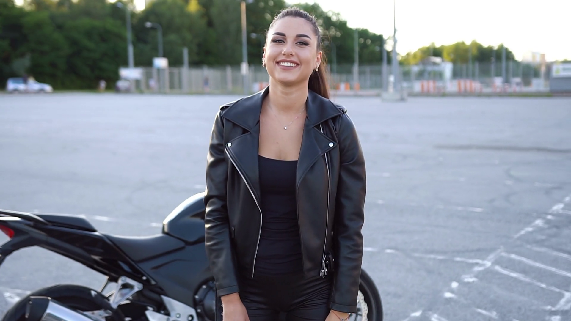 Good-looking positive elegant young modish female biker with ponytail ...