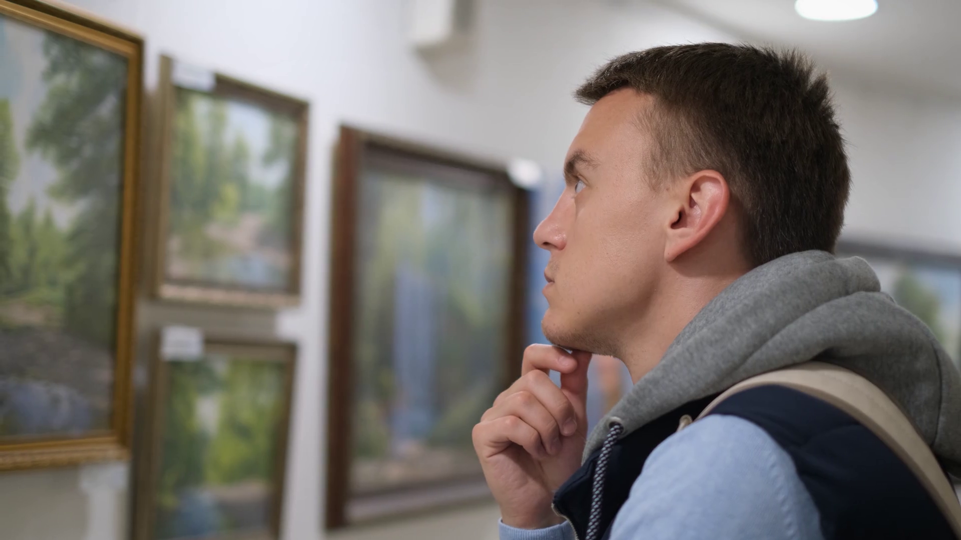 Young Man Looking At Paintings In Art Gallery Stock Footage SBV ...