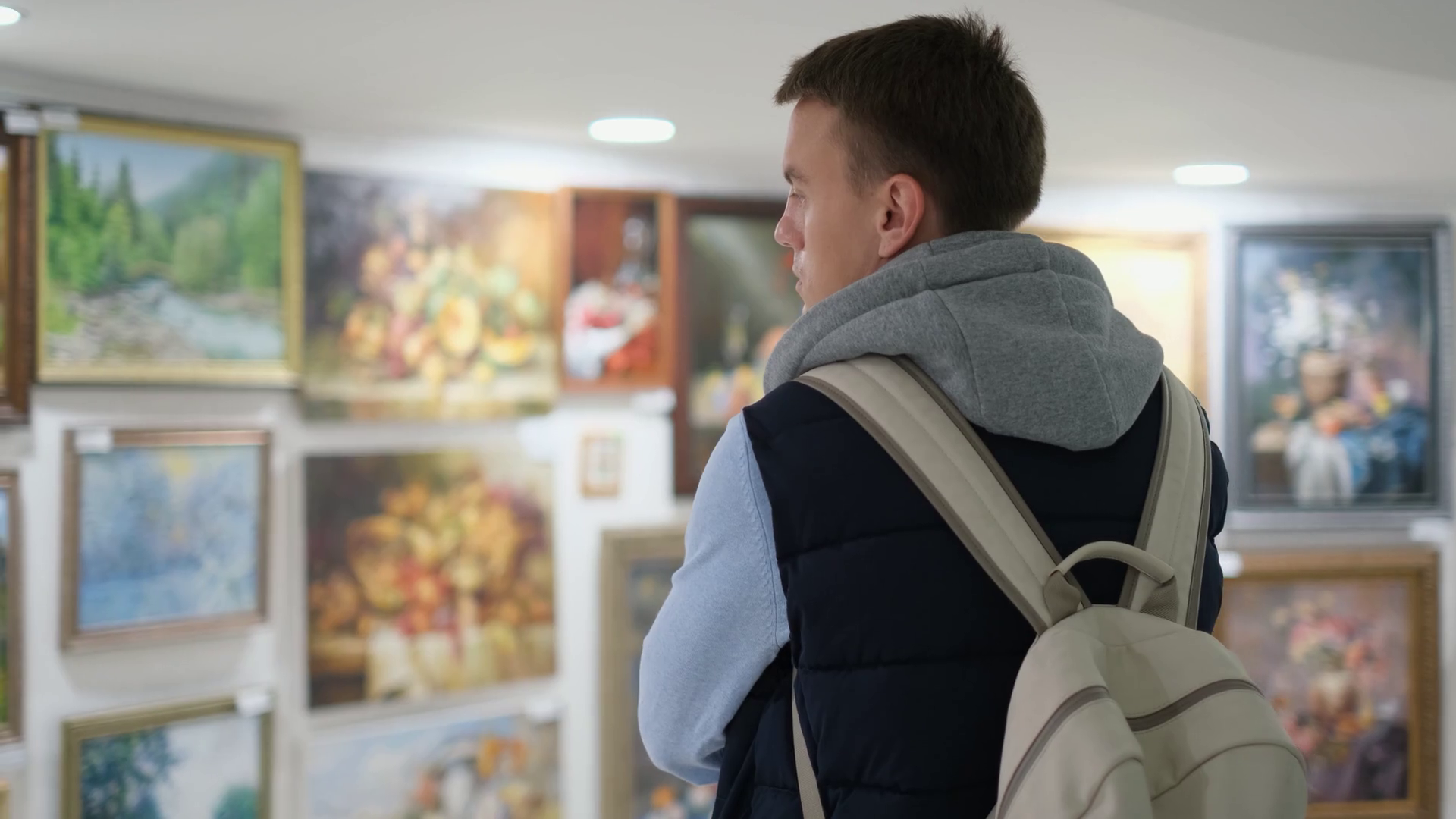 Young Man Looking At Paintings In Art Gallery Stock Footage SBV ...