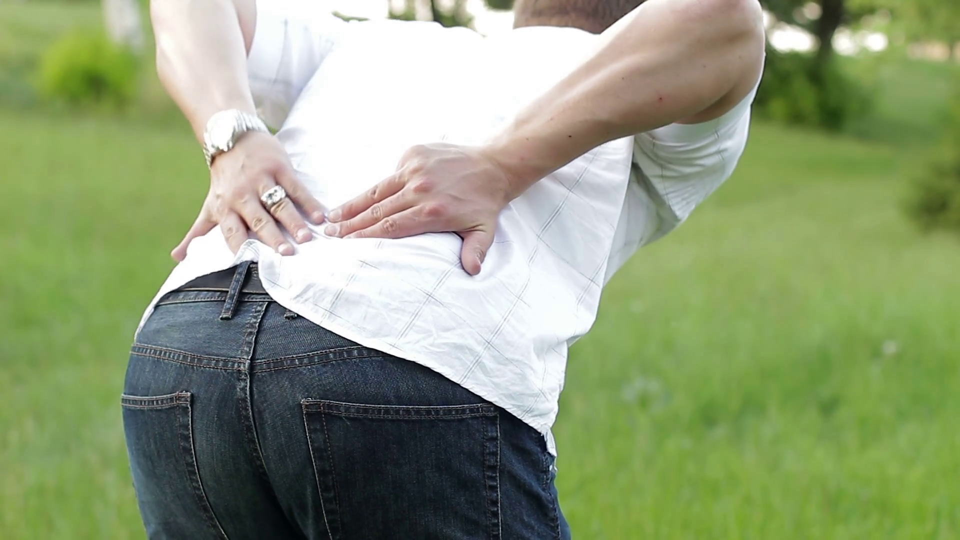 A man with a pain in his lower back holding on to his back Stock Video ...