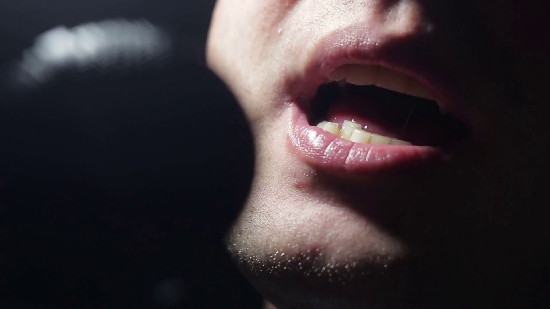 man singing song in the dark. The singer sings a song in the light of ...