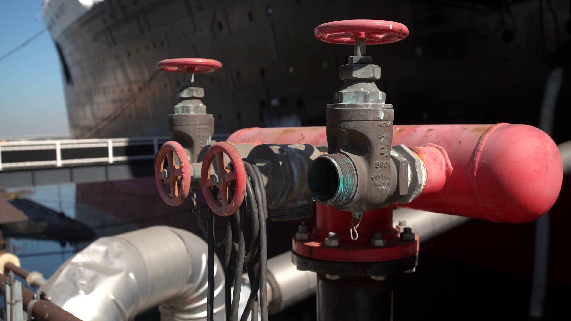 Thick plumbing tubes & pipes feed into plated hull of Queen Mary Ocean ...