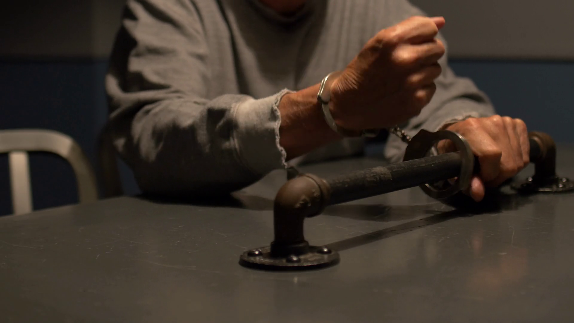 CLOSE UP - MAN HANDCUFFED TO INTERROGATION ROOM TABLE Stock Video ...