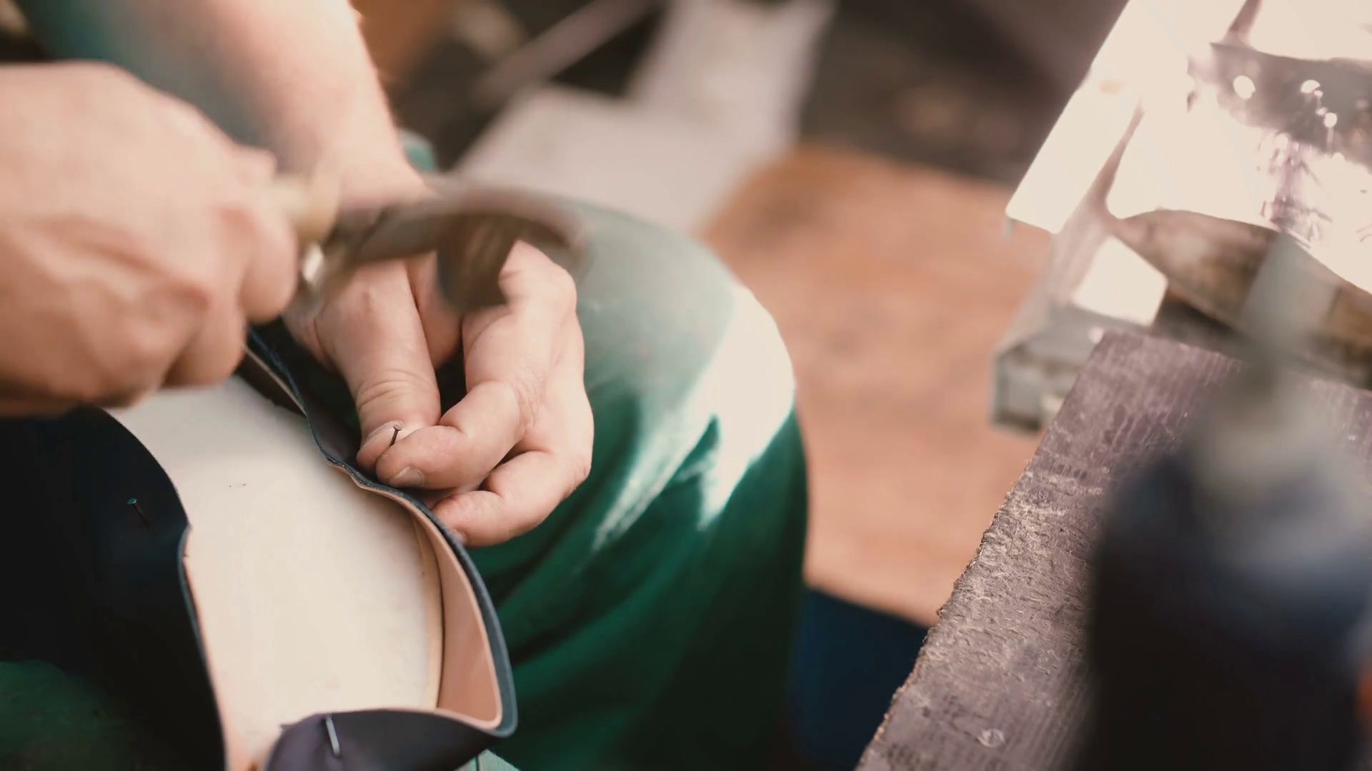 Close-up shot of skilled male shoemaker hands using special tool making ...