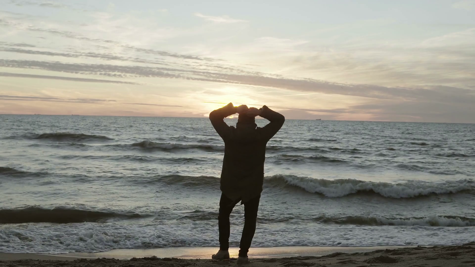 Man runs on the evening beach and throws sand. Male enjoying the nature ...