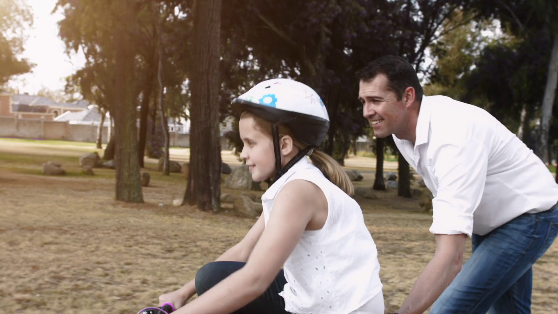 Father Teaching Daughter To Ride Her Pink Bike Steadicam Shot Stock