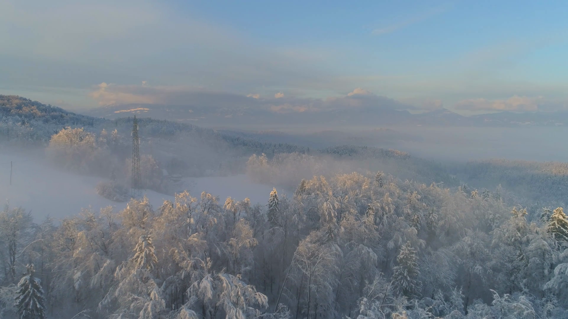 AERIAL: Flying over misty forest towards snowy countryside town at ...