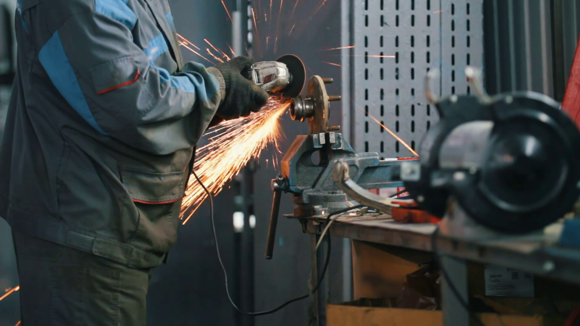 Car auto service - worker grinding metal construction with a circular ...