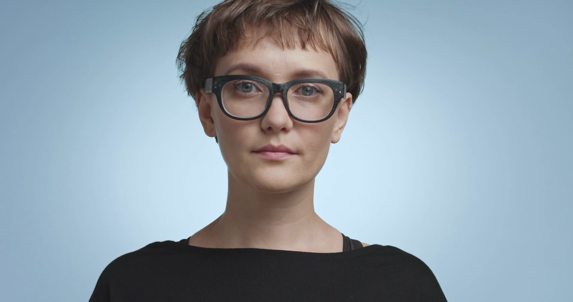 Pretty joyful smiling young woman with dark short hair wearing a black ...