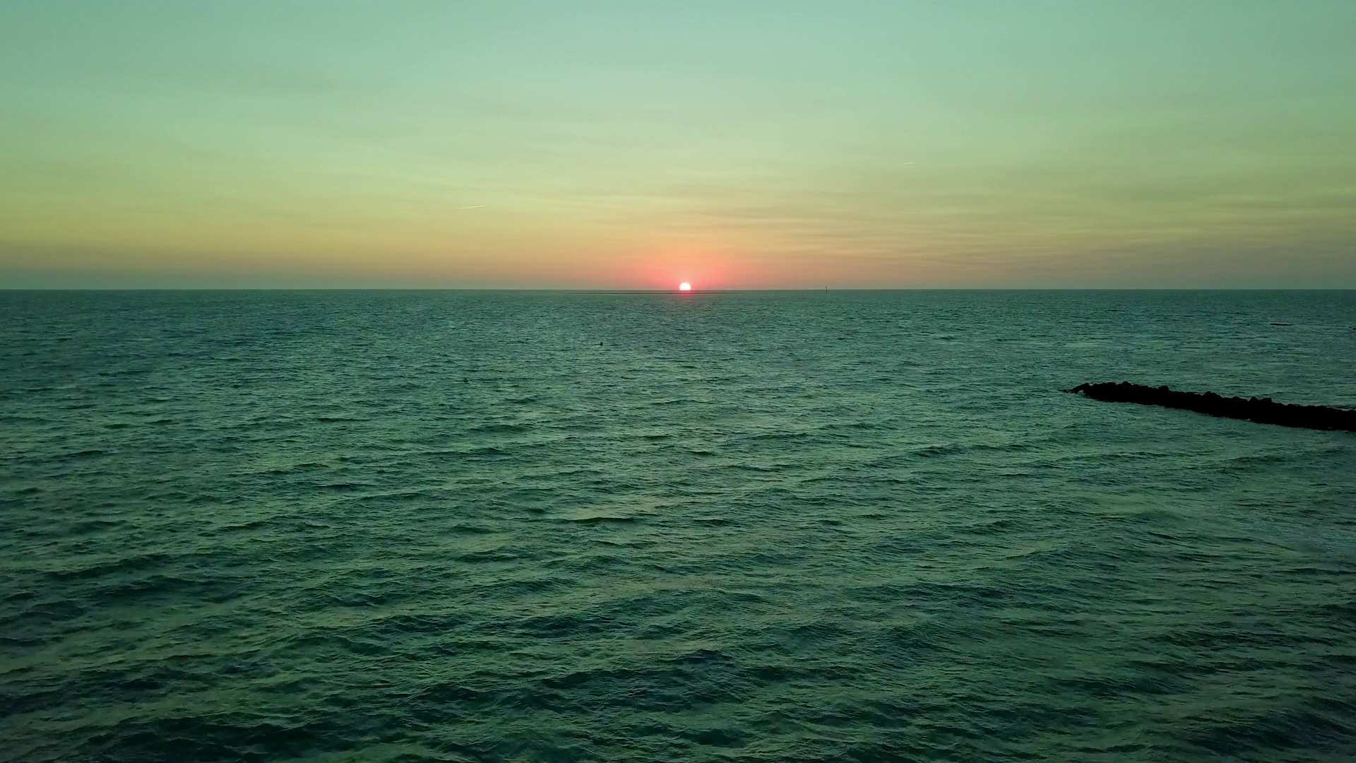 View of blue water ocean with slight ripple on background of sun rising ...