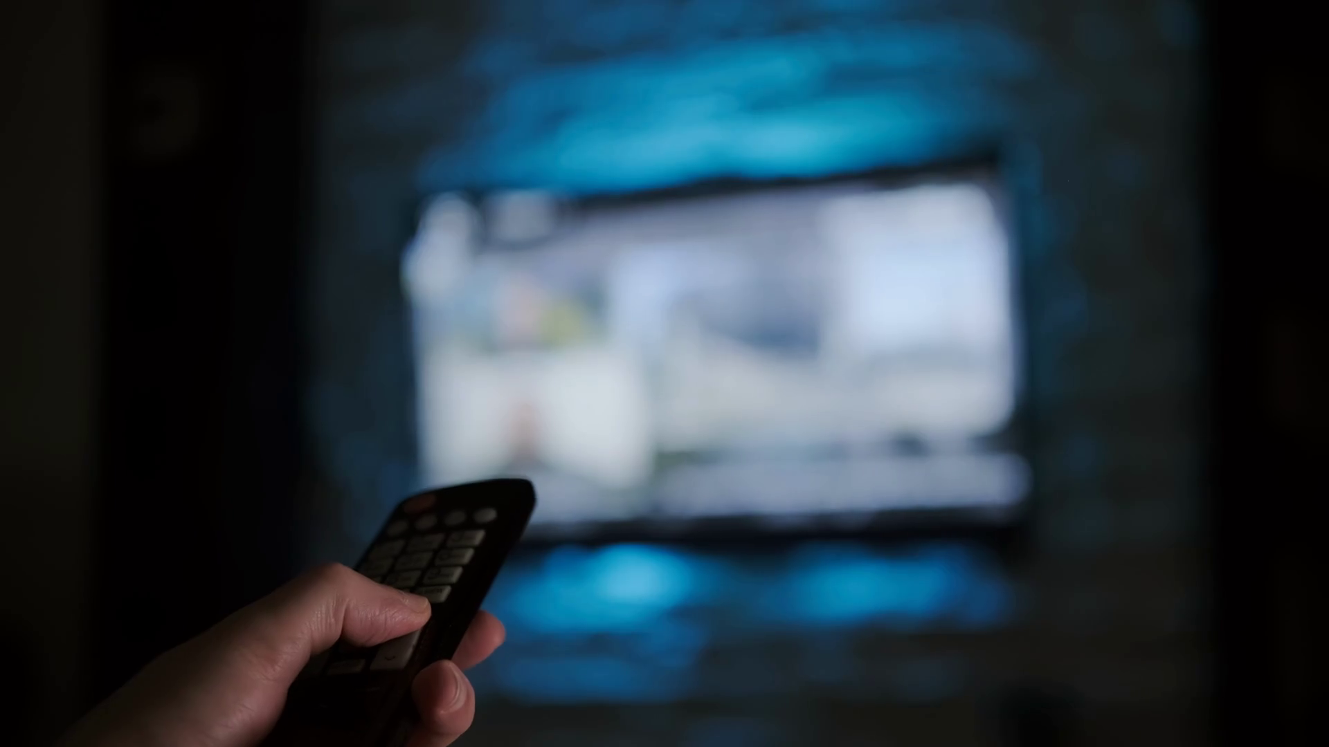 TV remote control surfing channels on television in night time Stock ...