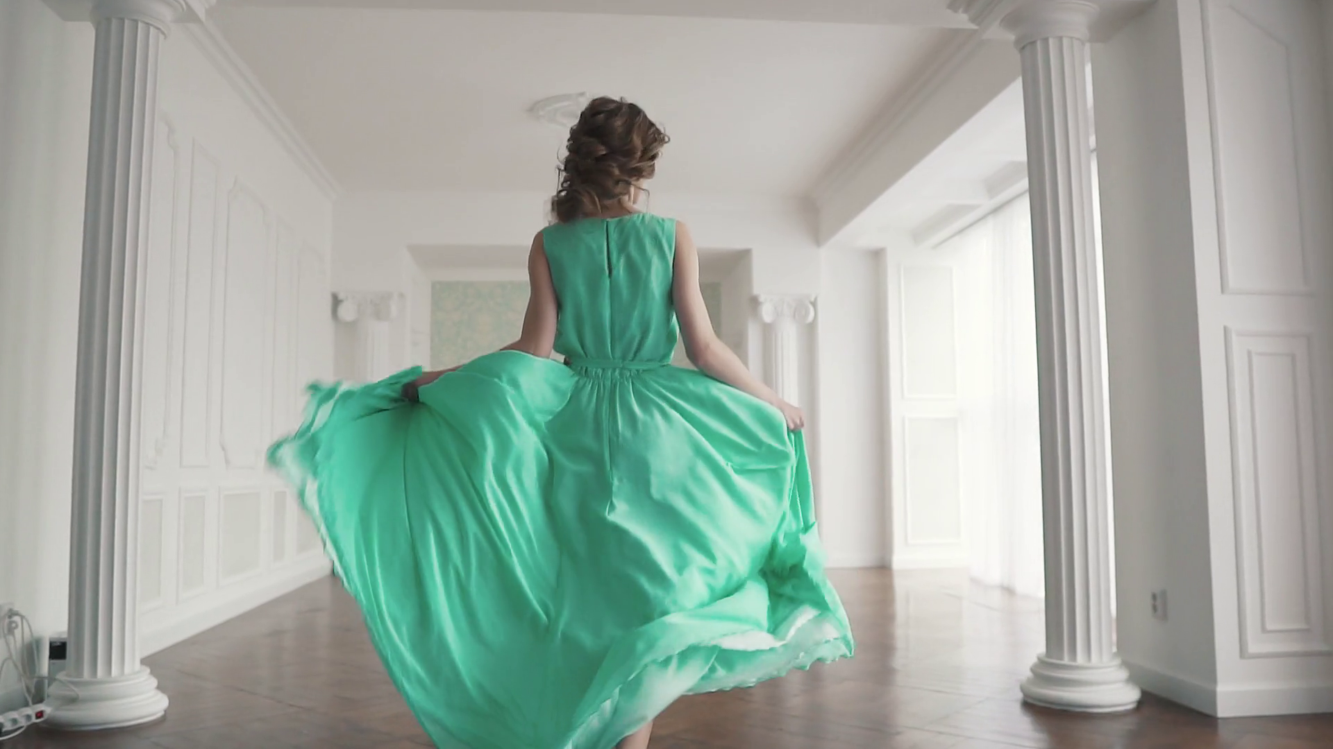 a fashionable girl in a fluttering dress runs away from the camera and ...