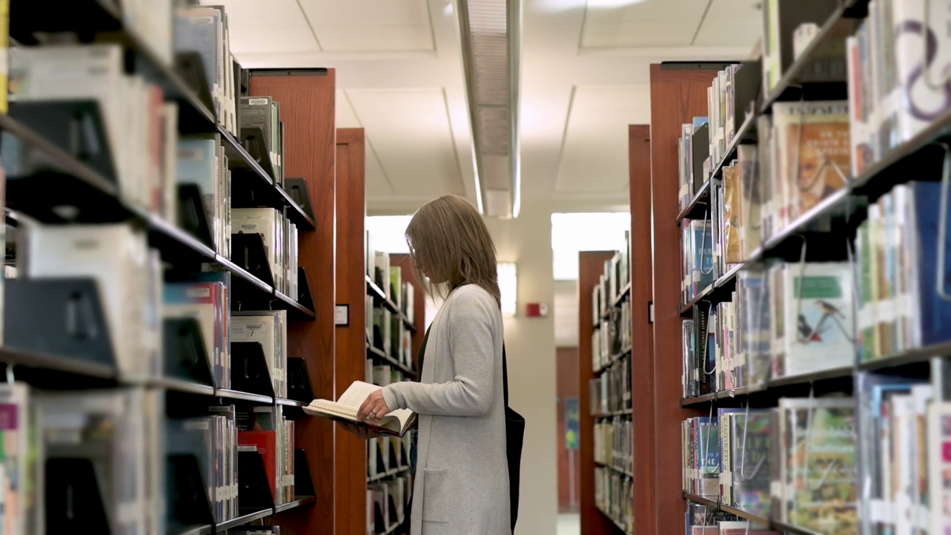 Woman Walking Through Library Aisle With Stock Footage SBV-352008417 ...