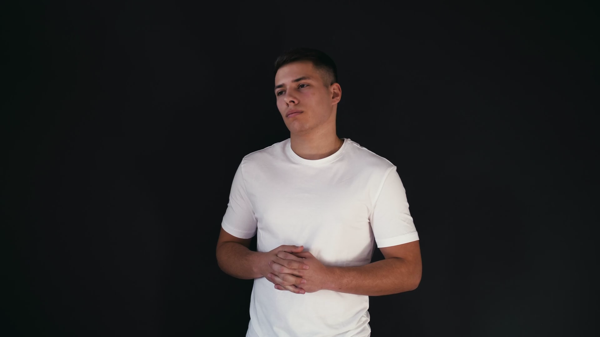 Video of young man lifts up one hand to chin. He moves this hand front ...