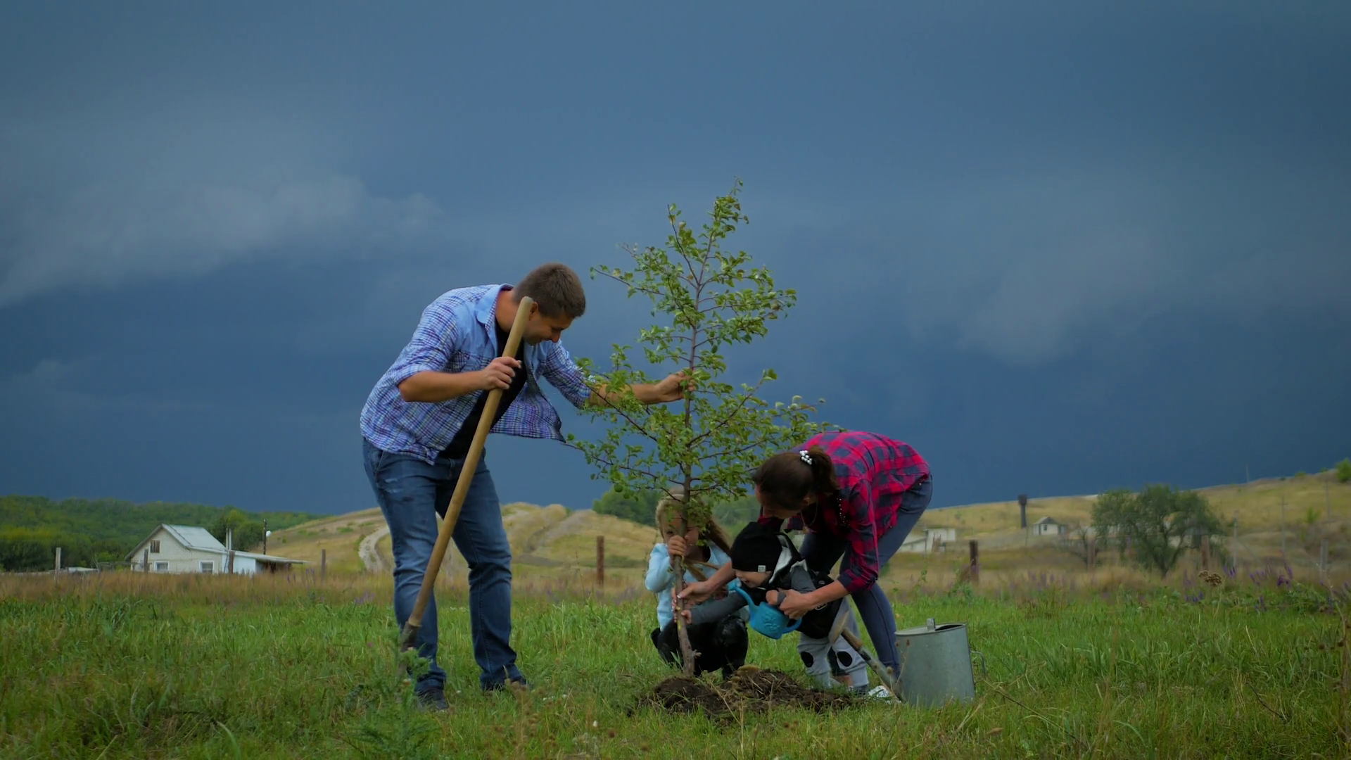 Family of four planting a new tree in his garden. The concept is to ...