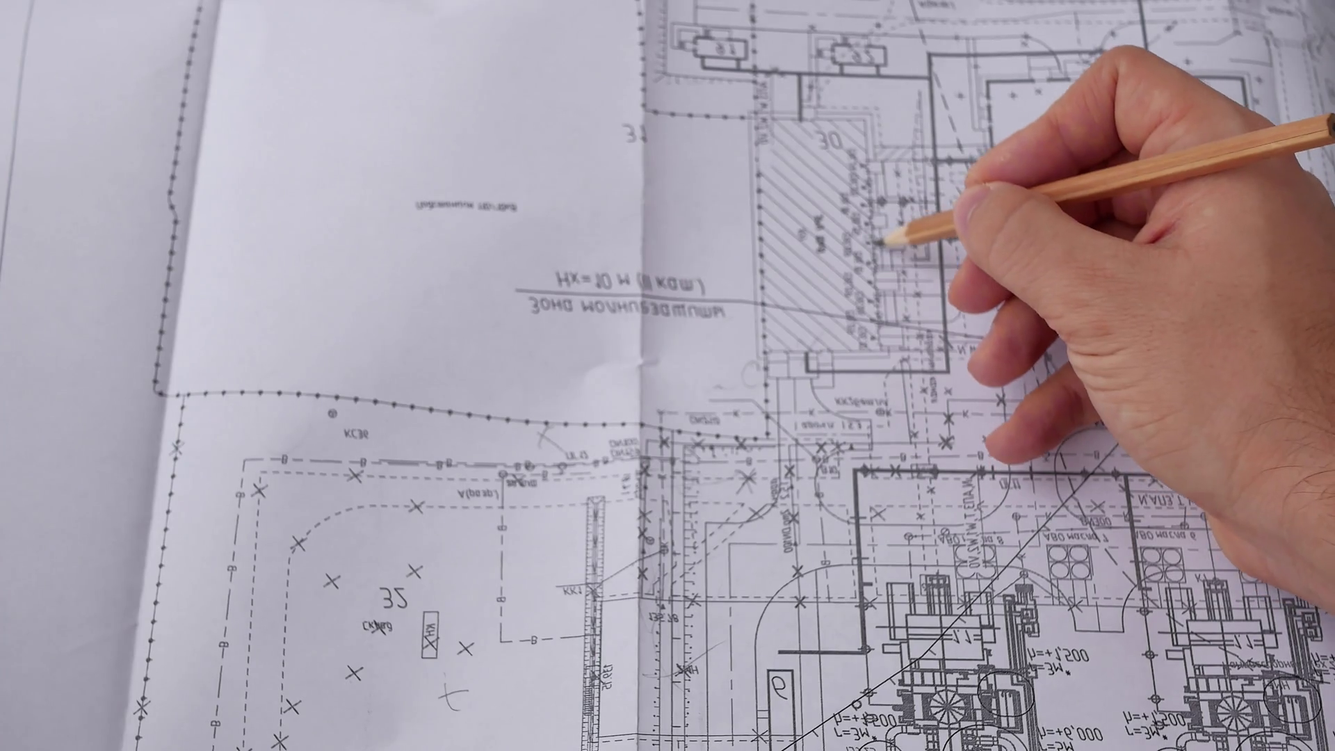 Macro close up of quantity surveyors hand reviewing technical drawing ...